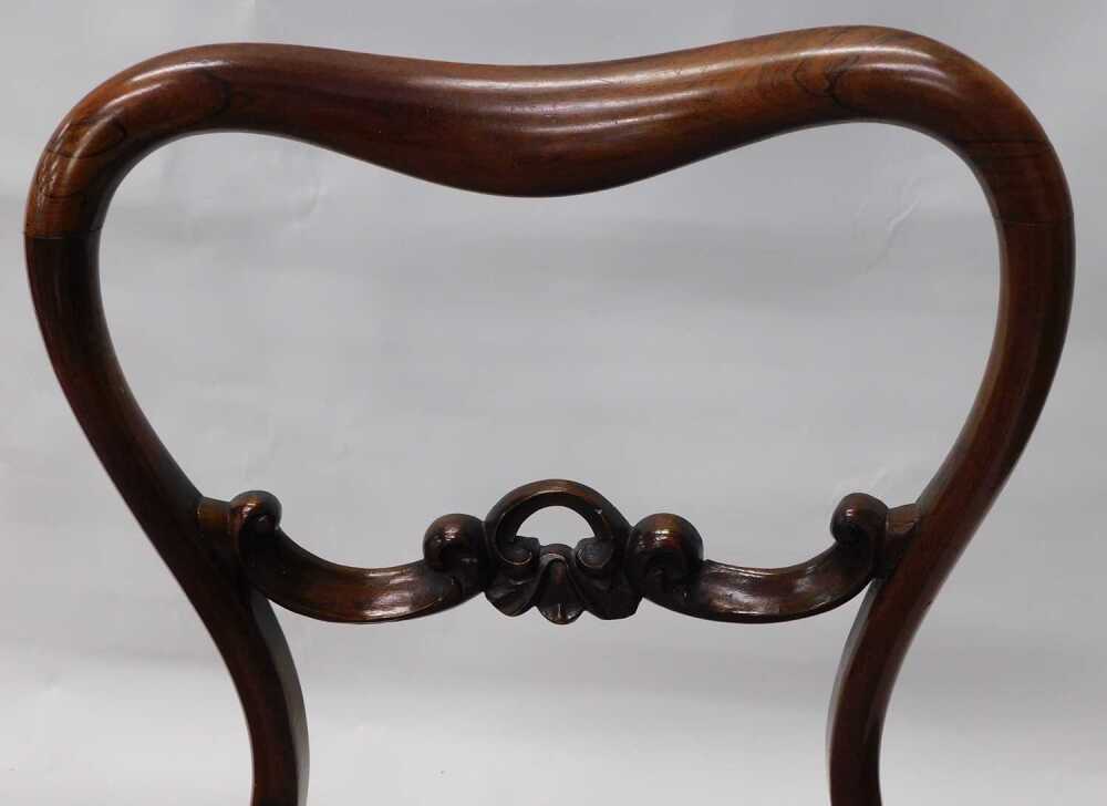 A set of six Victorian rosewood balloon back chairs, each with a ...